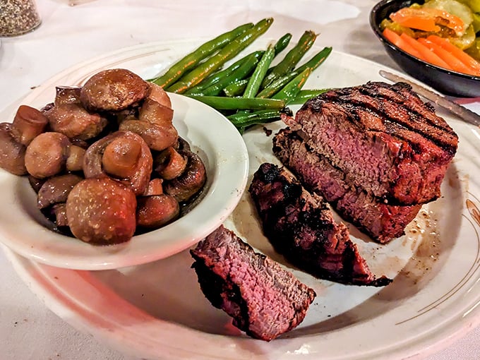 Juicy steak, saut&eacute;ed mushrooms, and fresh green beans &ndash; the holy trinity of steakhouse satisfaction arranged with care.