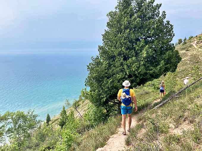 Adventurers trace the edge of Michigan's magnificent coastal bluffs, where every step offers postcard-worthy views of turquoise waters below.