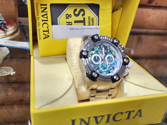 An Invicta watch waits patiently in its box, ready to adorn a wrist with the kind of statement piece that says, "Yes, I still believe in mechanical timekeeping."