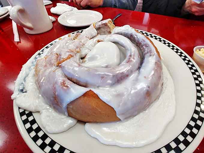 Size matters! This mammoth cinnamon roll requires commitment, determination, and possibly a post-breakfast nap to conquer properly.