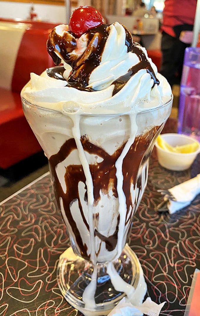 This isn't just a milkshake &ndash; it's a skyscraper of dairy delight, where whipped cream meets chocolate in a romance that's lasted generations.