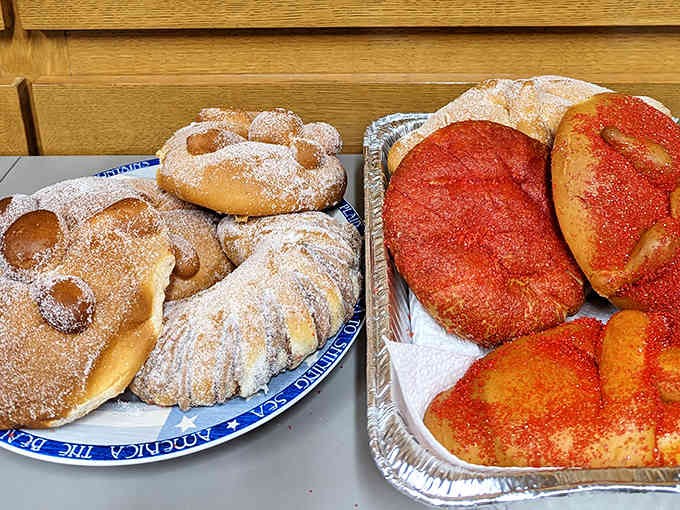 Sweet treasures await! Traditional pan de muerto dusted with sugar sits alongside colorful conchas &ndash; the perfect ending to any Mexican feast.