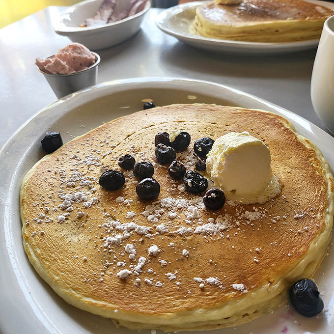 Golden pancakes topped with fresh blueberries and a melting pat of butter &ndash; simple perfection that reminds you why breakfast is the best meal.