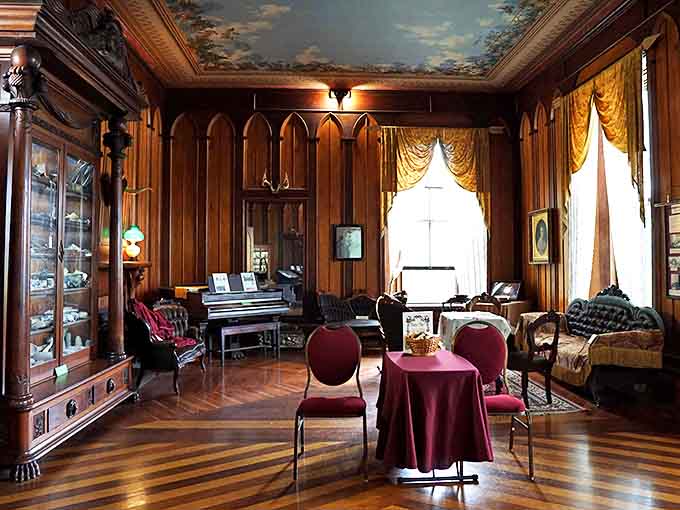 The parlor's ornate ceiling, elegant furnishings, and period details create an atmosphere where you can almost hear the whispers of 19th-century social gatherings.