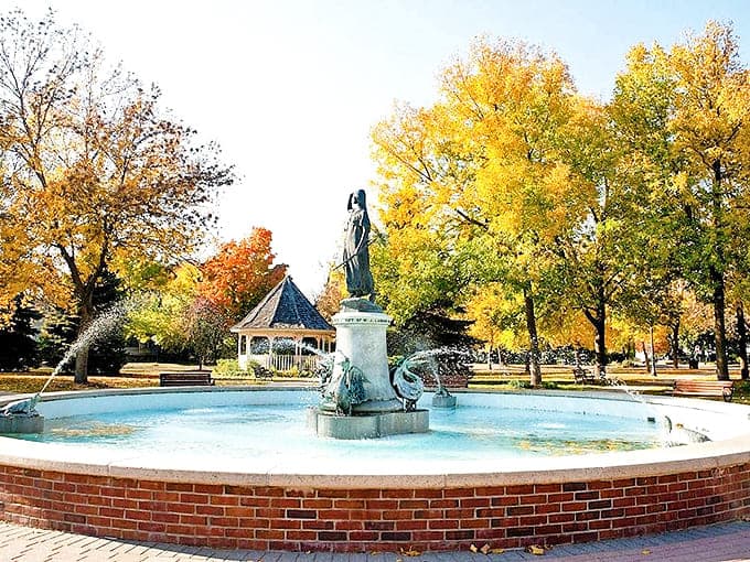 The Princess Wenonah Fountain creates a peaceful oasis in Windom Park, where water dances beneath golden trees.
