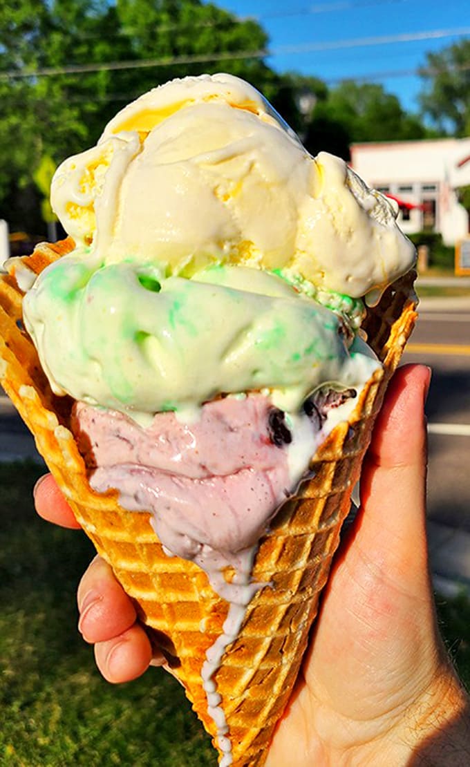Three scoops of summer bliss – each color promising a different adventure for your taste buds in one magnificent waffle cone.