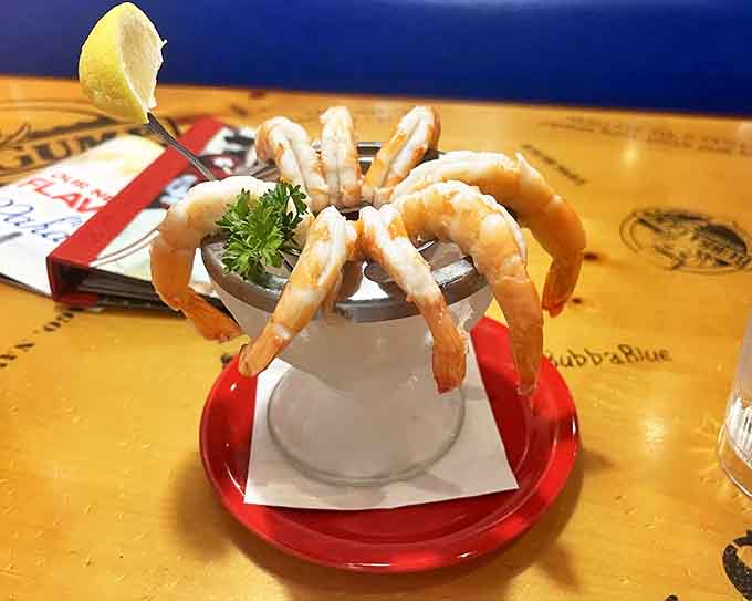 The shrimp cocktail arrives like ocean royalty on a throne of ice, practically begging to be dunked in that zesty sauce.
