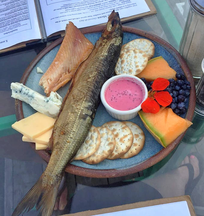 A feast for the senses: smoked cisco surrounded by local cheeses, crackers, and fresh fruit creates a shareable appetizer worth fighting over.