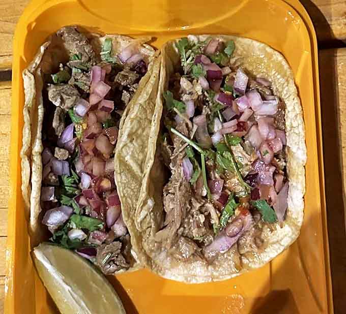 Traditional street tacos showcase the beauty of simplicity: fresh cilantro and diced onion letting quality meat shine through handmade tortillas.