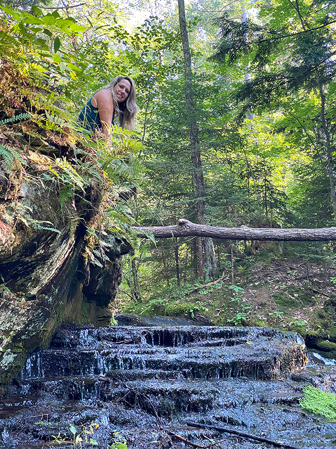 Perched above the falls, a hiker enjoys the reward after the journey &ndash; sometimes the best views require a little climbing.