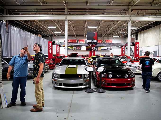 Automotive dreams come alive as enthusiasts admire these mechanical masterpieces&mdash;notice how everyone stands just a little straighter near greatness.