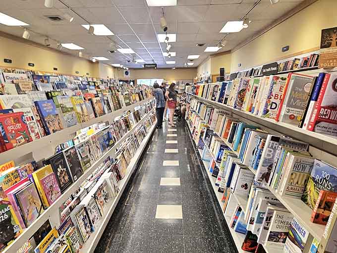 Browsers navigate the black-and-white checkered path between worlds, each aisle offering a different journey without ever leaving Holland, Michigan.