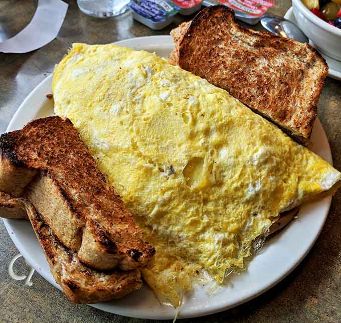 Behold the omelet in all its glory &ndash; fluffy, generous, and practically bursting with fillings, flanked by toast soldiers ready for action.