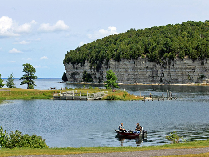Anglers find serenity on Big Bay de Noc's crystal waters, fishing beneath limestone cliffs that once fueled Michigan's iron industry.