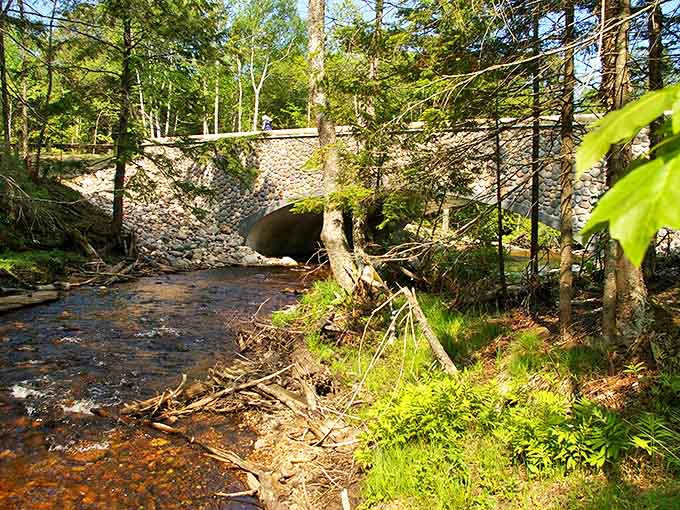 This charming stone bridge along H-58 doesn't just span a creek&mdash;it connects travelers to Michigan's rich history and natural splendor.