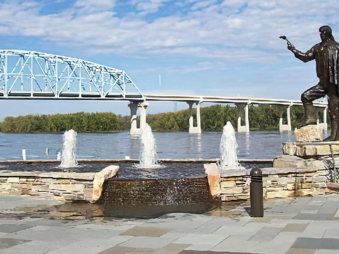 Water dances skyward as if celebrating its journey from the mighty Mississippi, with the river's iconic bridge standing proudly behind.