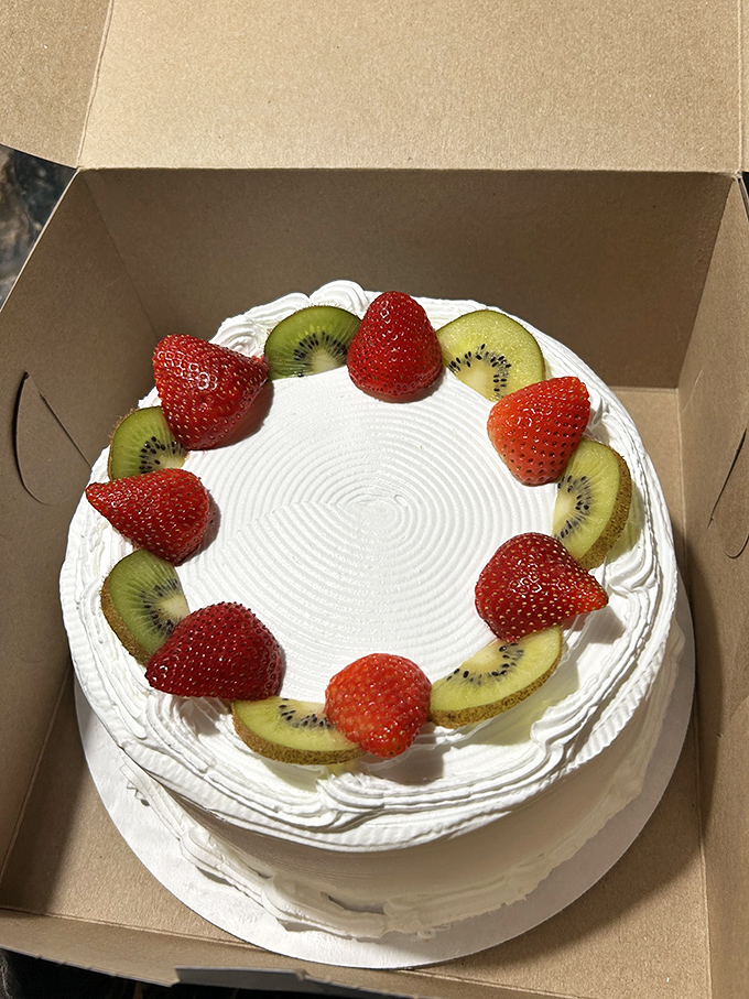 A work of art you can eat &ndash; fresh strawberries and kiwi crown this pristine white cake, creating a simple yet stunning presentation.
