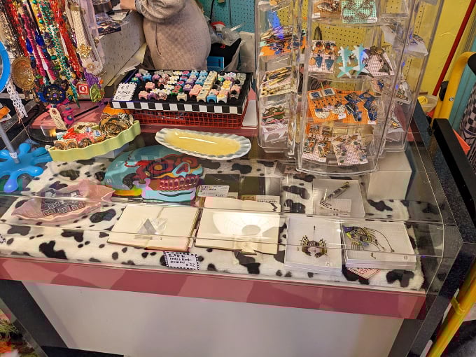 Treasure hunting at its finest! This display case showcases an eclectic mix of colorful trinkets that would make any 90s kid's collection complete.