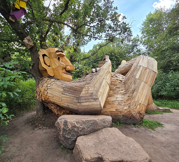Lounging comfortably among the trees, this wooden troll seems to have found the perfect spot for an afternoon nap.