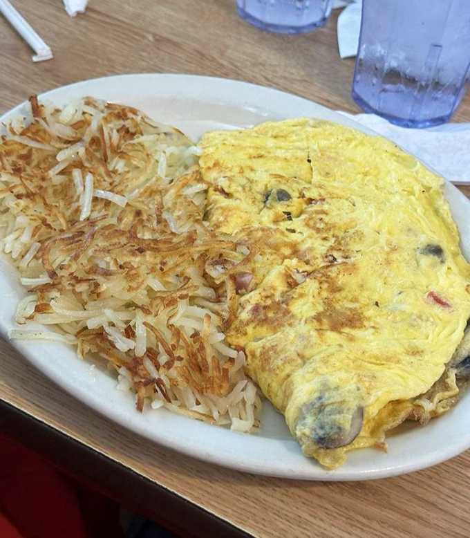 A perfect omelet nestled beside hash browns so crispy they practically sing when your fork hits them.