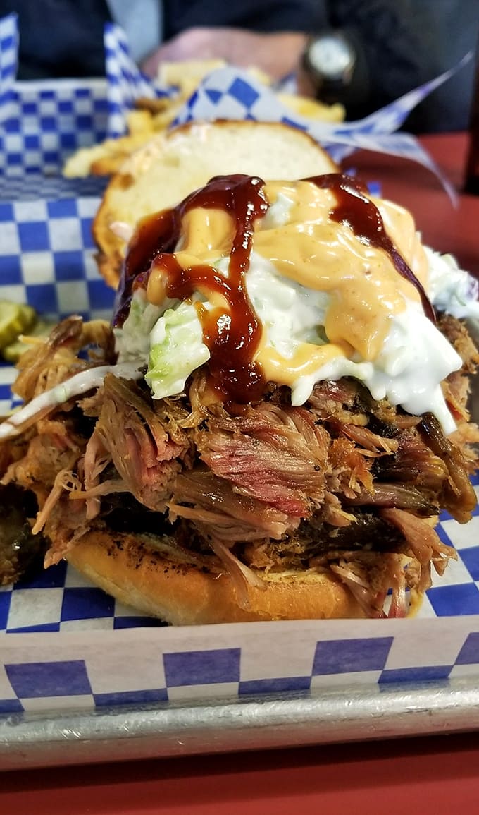 Pulled pork sandwich: A masterpiece of textures &ndash; smoky pulled pork meets cool, crisp slaw under a drizzle of house sauce that'll make you weak in the knees.