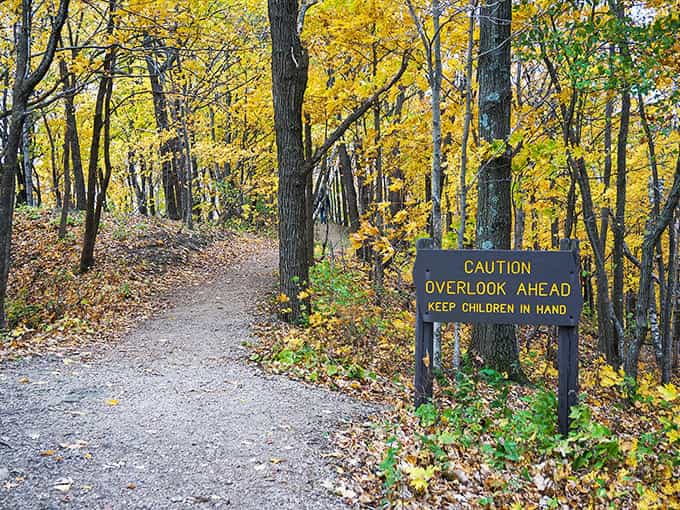 The trail's gentle warning sign stands sentinel among golden leaves, like nature's own "proceed with caution but prepare to be amazed."