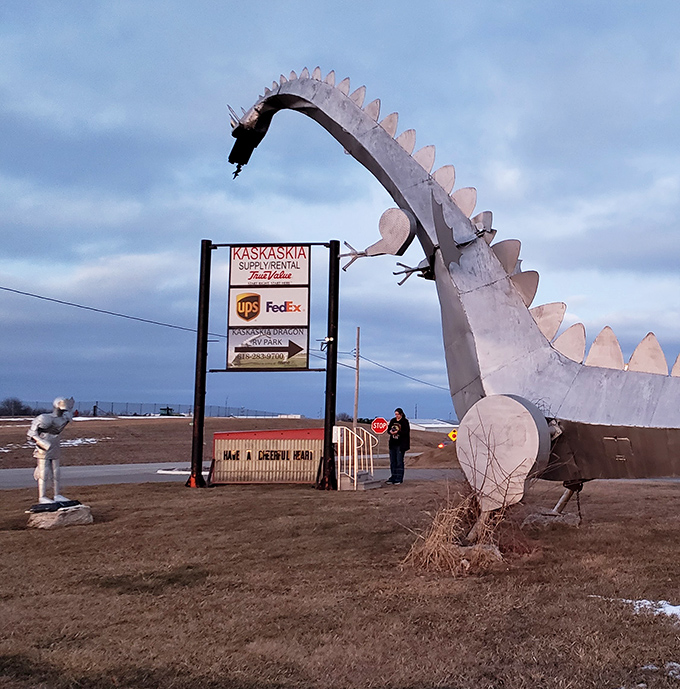 A visitor stands ready at the control box, about to experience the thrill of commanding fire from a mythical beast.