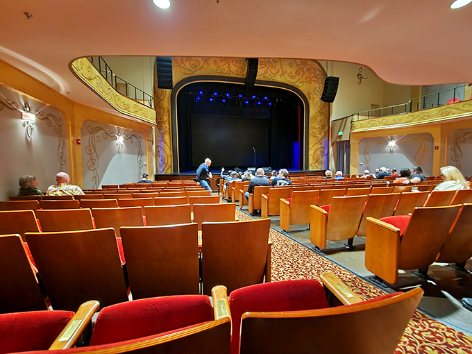 The warm amber glow of the theater creates that magical moment of anticipation as patrons settle in, waiting for the house lights to dim.