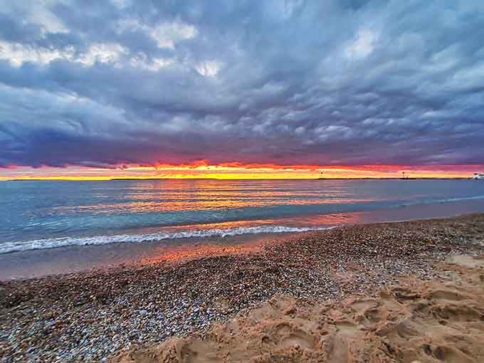 Twilight brings a touch of magic to Van&rsquo;s Beach, with sunset tones dotting the shoreline under a cloudy sky.