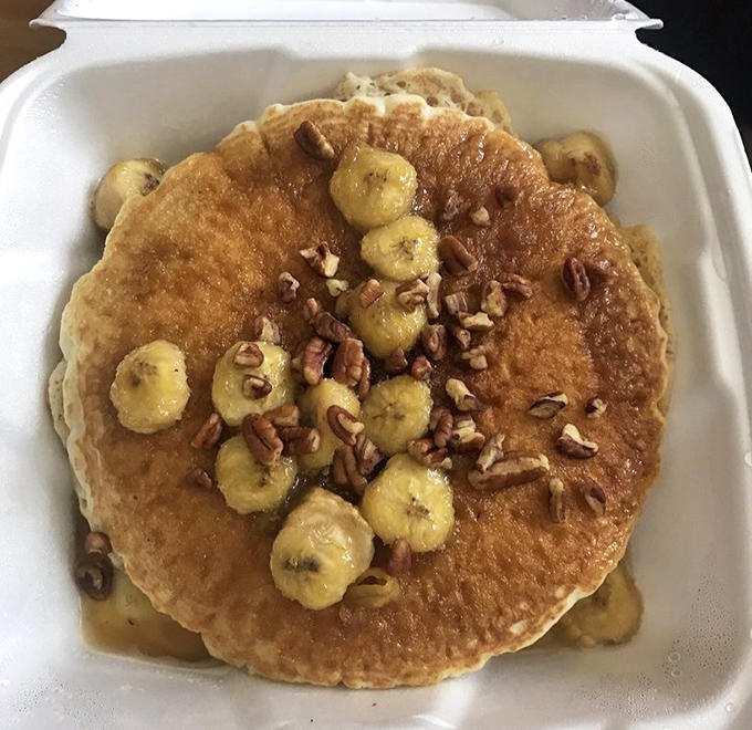 Banana Foster pancakes topped with caramelized bananas and crunchy pecans &ndash; where breakfast meets dessert in perfect harmony.