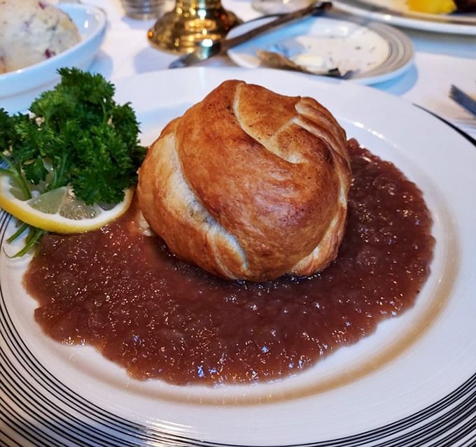 Another angle of the famous Beef Wellington shows the architectural precision &ndash; flaky pastry exterior giving way to tender meat within.