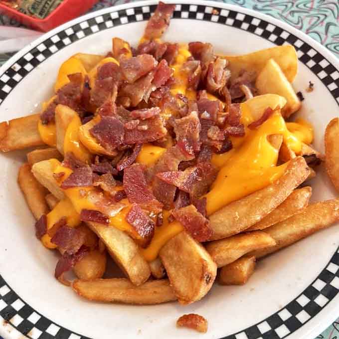 Golden potato perfection blanketed in melted cheddar and crowned with crispy bacon bits &ndash; a masterpiece that puts regular fries to shame.