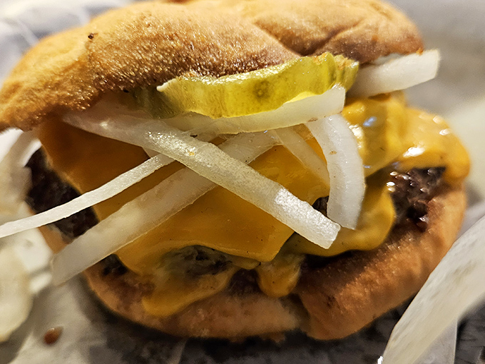 This isn't just a burger – it's a statement. Topped with pickles and raw onions, it's a force to be reckoned with.