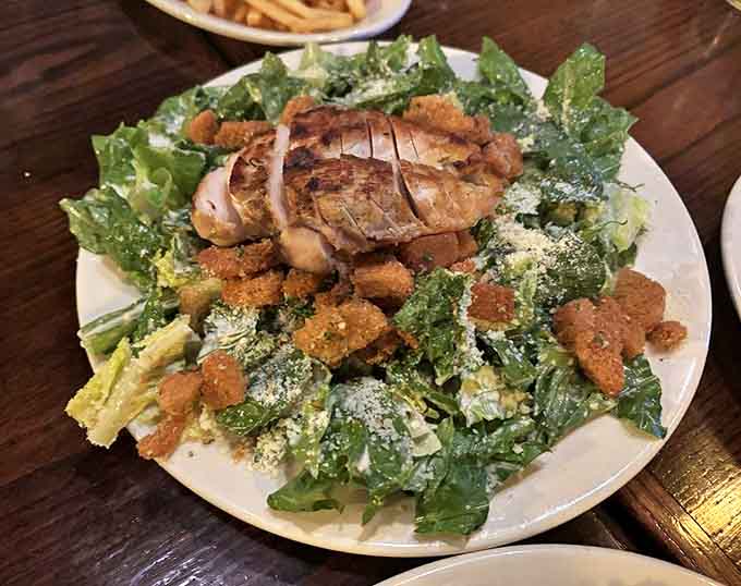 A Caesar salad that respects tradition &ndash; crisp romaine, house-made dressing, and grilled chicken that actually tastes like chicken should.