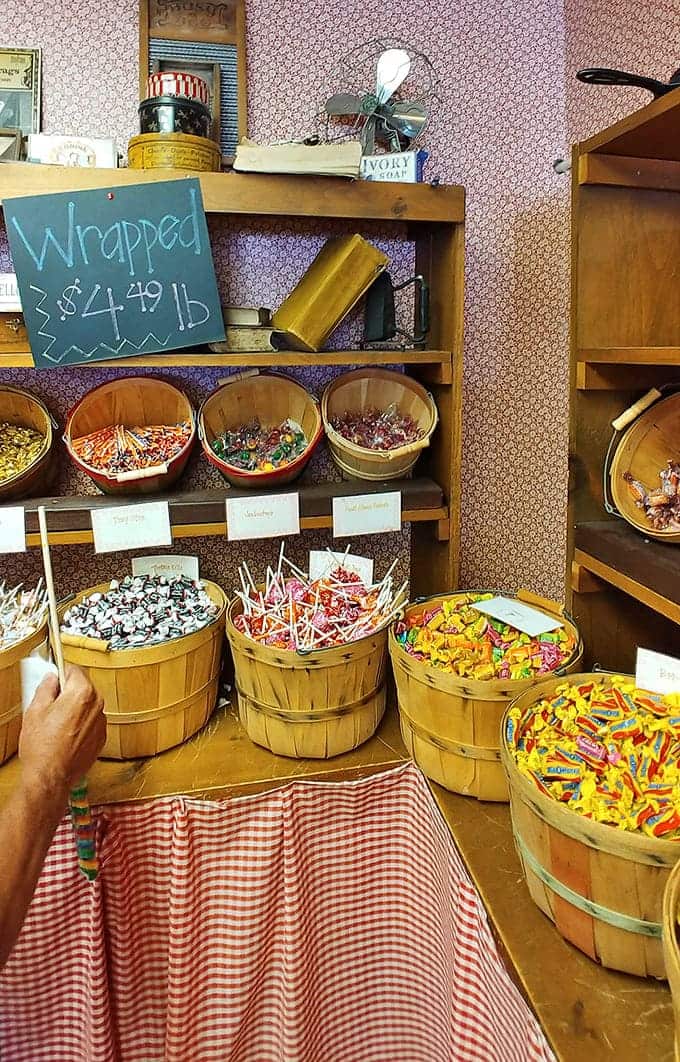 Wooden bushel baskets brim with wrapped candies, organized by color like a rainbow decided to retire here.