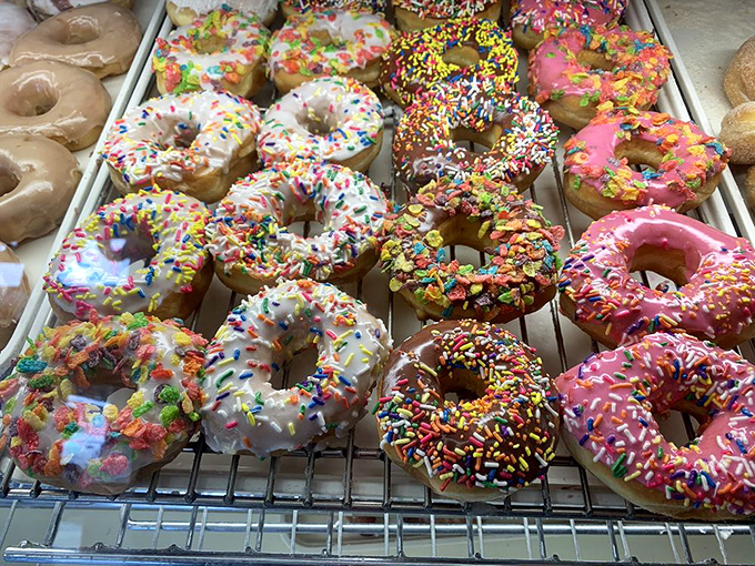 Rainbow sprinkles dance across perfectly glazed donuts, arranged with the precision of jewels in a display case, each promising a different sweet adventure.