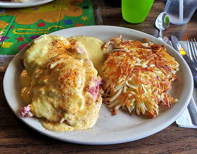 Eggs Benedict done right &ndash; perfectly poached eggs nestled on ham, draped in hollandaise, with crispy hash browns standing guard against hunger.