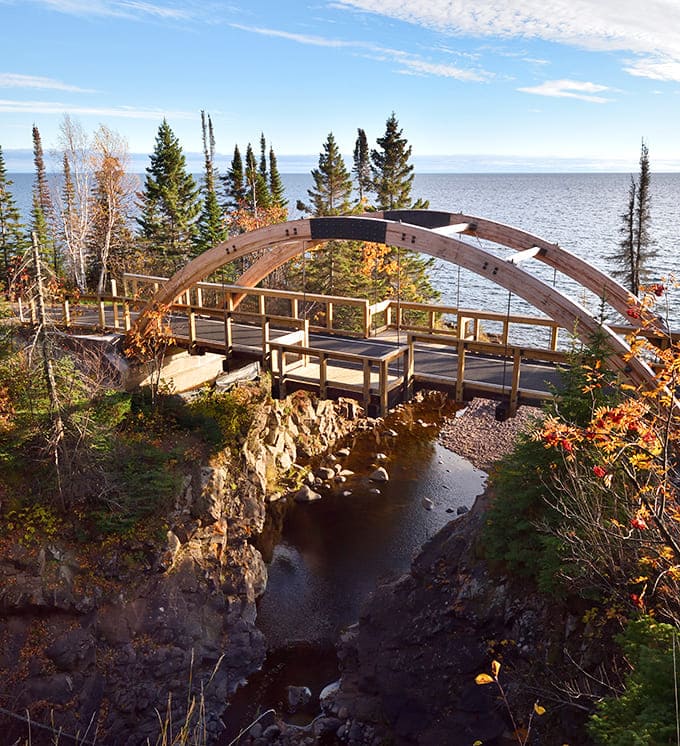 The arched bridge frames the falls like a perfect picture window, proving humans occasionally get architecture right.