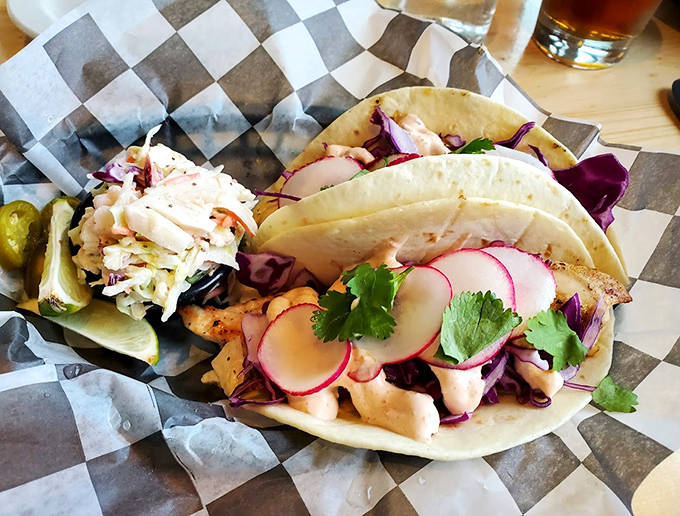 Fish tacos reimagined North Shore style &ndash; tender whitefish nestled in soft tortillas with crisp vegetables and bright, zesty garnishes.