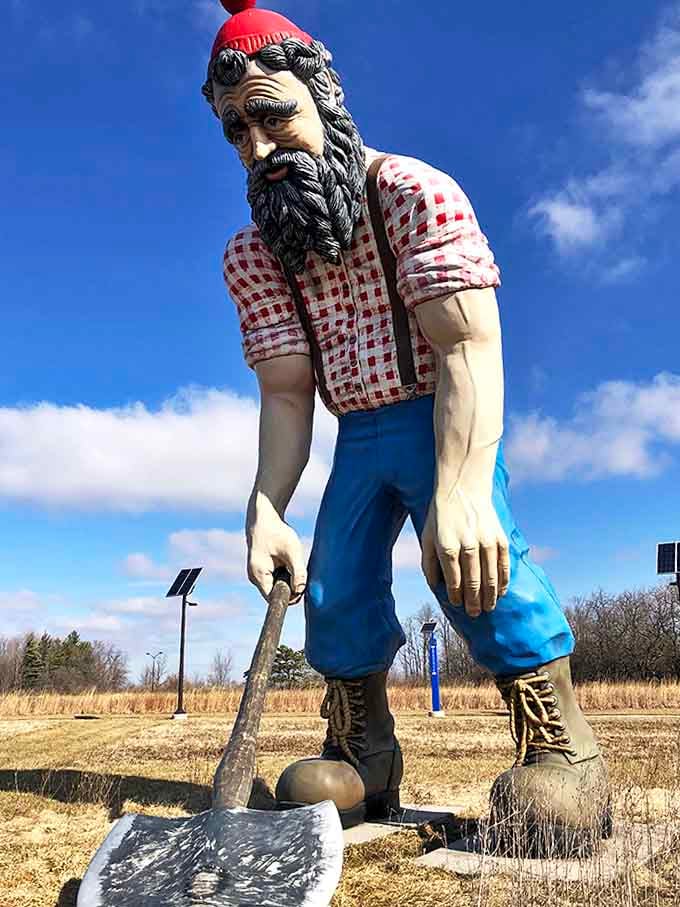 Paul the lumberjack stands tall in his checkered shirt and red cap, forever paused mid-chop, a gentle giant watching over the prairie.