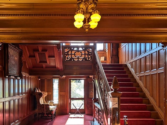 Dark wood paneling and crimson carpet create a dramatic ascent that practically begs for someone to make an entrance worthy of classic cinema.