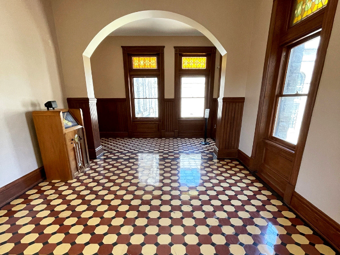 This polished hallway with its distinctive pattern leads visitors deeper into the reformatory, each step echoing with decades of history.