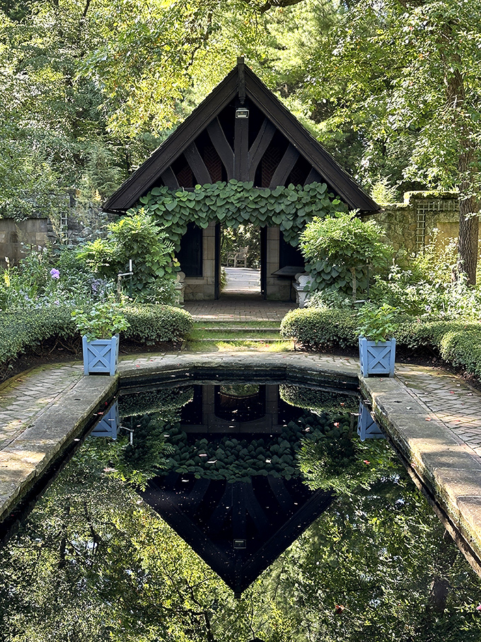 This charming garden pavilion reflects perfectly in still waters, doubling the beauty in a mirror image that captivates photographers.