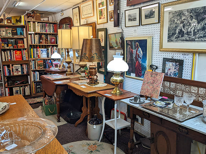 Vintage lamps cast a warm glow over carefully arranged vignettes, creating cozy corners that feel like stepping into a bygone living room.