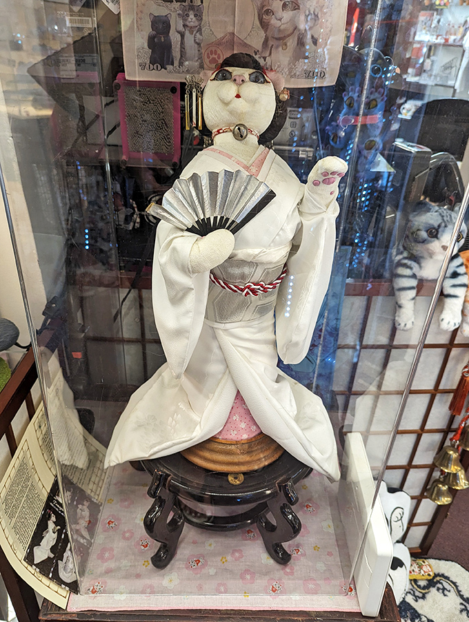 A delicate cat figurine dressed in traditional Japanese kimono demonstrates the craftsmanship behind these cultural ambassadors of good fortune.