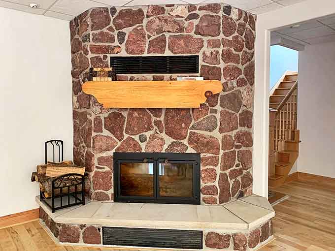 The stone fireplace anchors this living space with rustic charm, promising evenings of crackling fires and conversation that flows as easily as the wine.