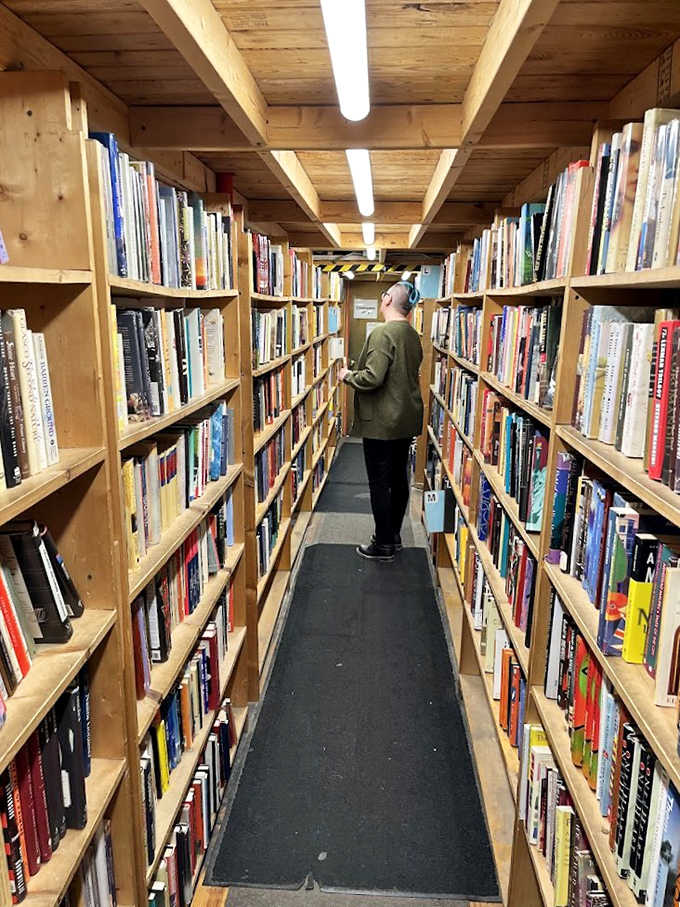 Narrow passages between towering bookshelves create an intimate browsing experience &ndash; like walking through someone's personal library collection.