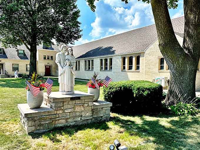 Holy Family Catholic Church stands as a serene spiritual landmark in Oglesby, its stone statue and American flags reflecting the town's deep community roots.
