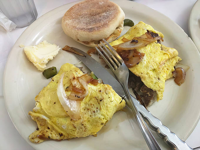 The breakfast plate features a golden omelet with caramelized onions alongside a toasted English muffin &ndash; simple food done extraordinarily well.