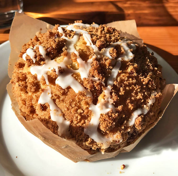 The pecan cinnamon crumb cake creates a perfect textural symphony &ndash; tender cake base, crunchy streusel topping, and tangy cream cheese drizzle.